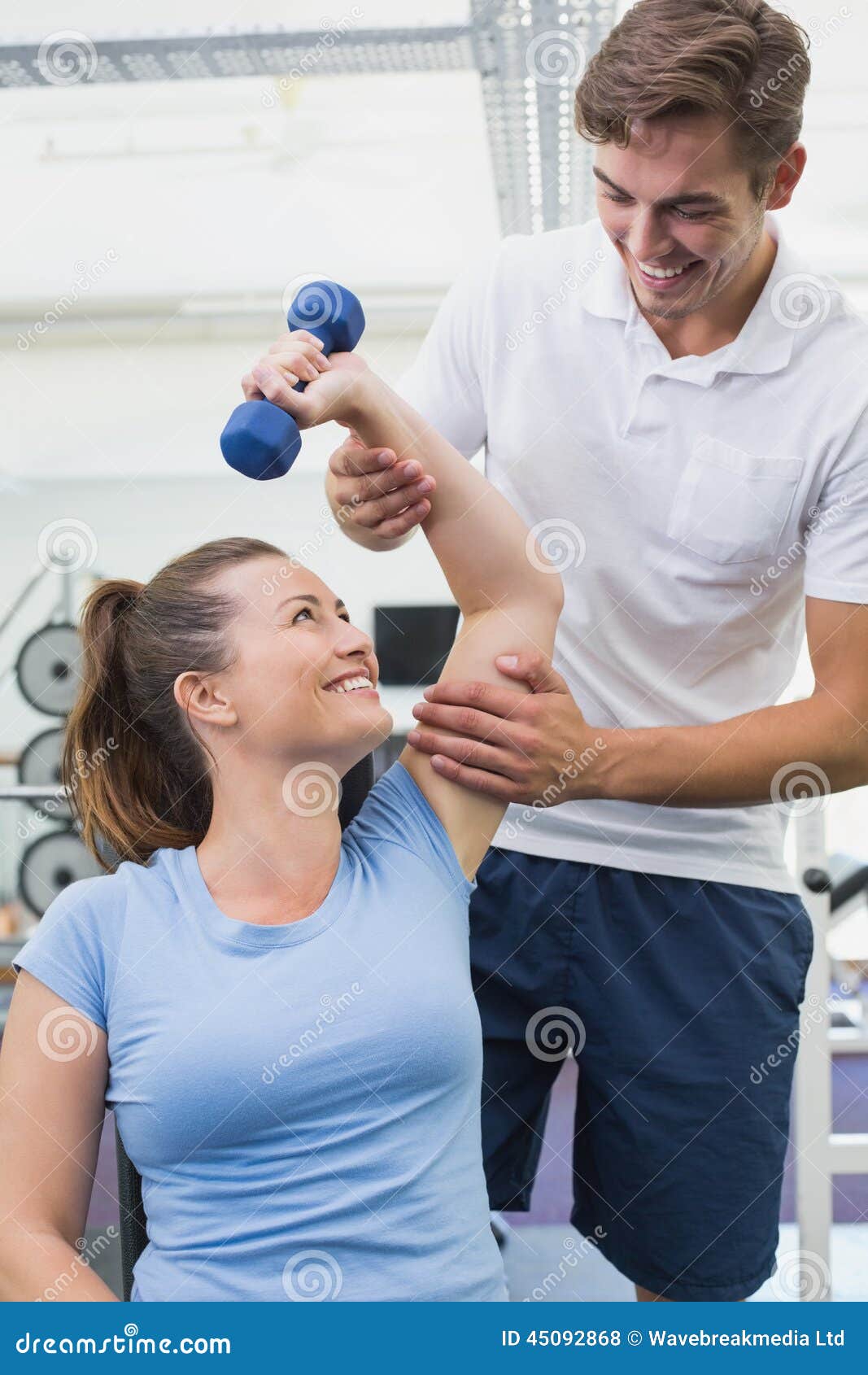 Personal Trainer Helping Client Lift Dumbbell Stock Photo - Image of ...