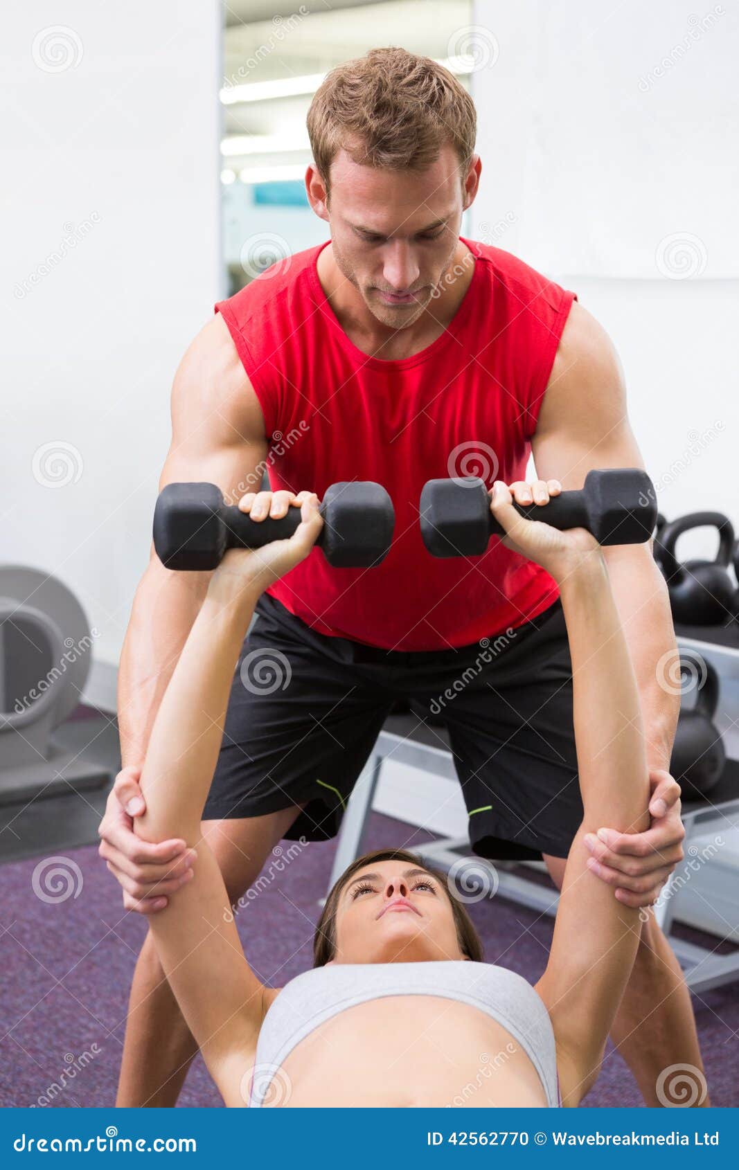 Personal Trainer Helping Client Lift Dumbbells Stock Photo - Image of ...