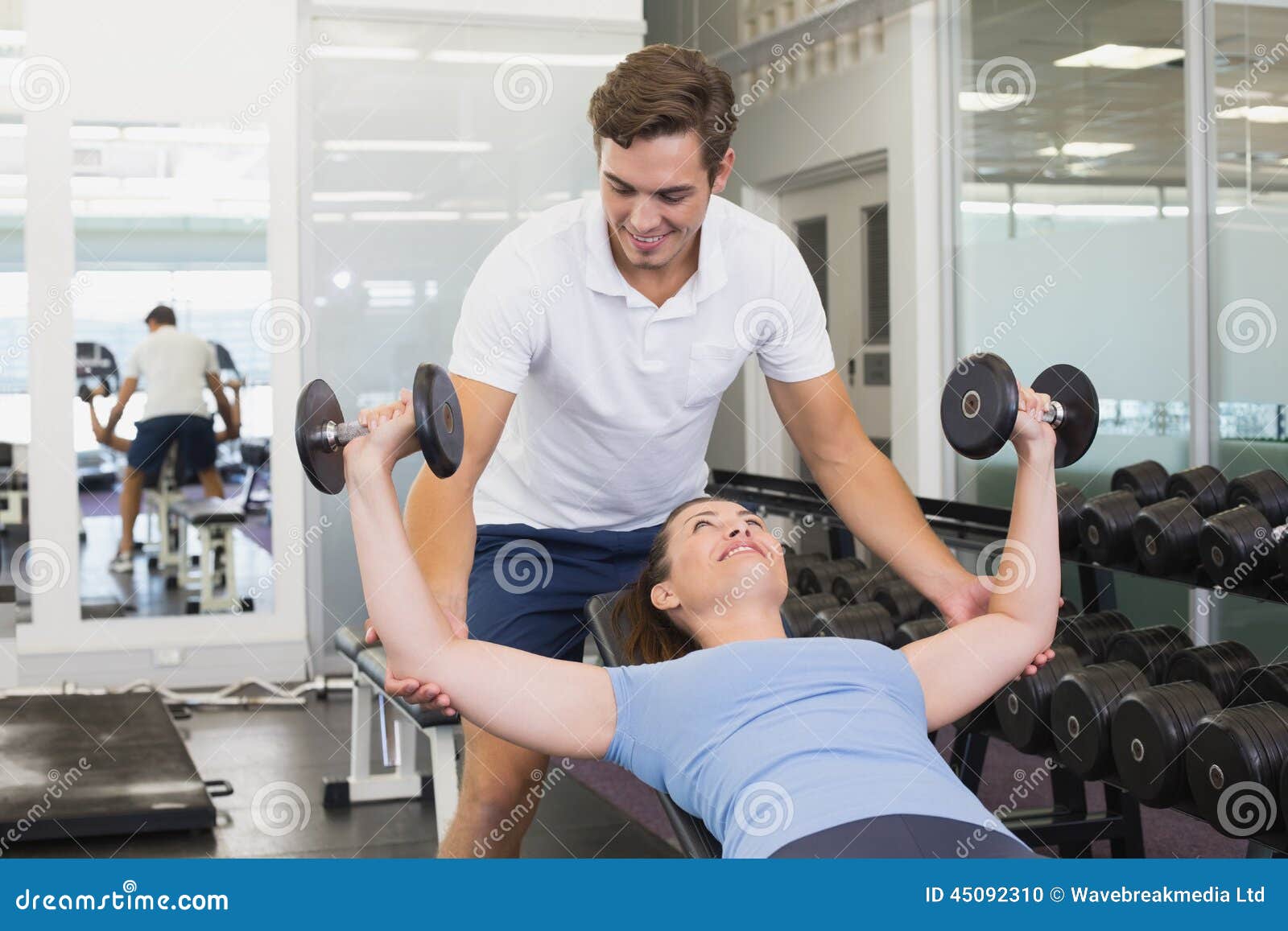Personal Trainer Helping Client Lift Dumbbells Stock Photo - Image of ...