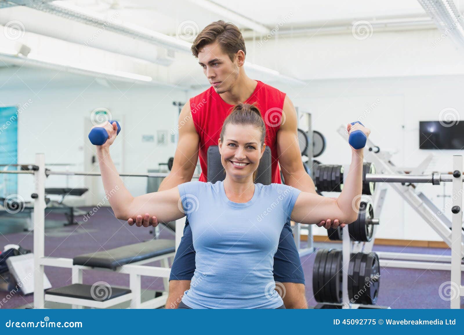 Personal Trainer Helping Client Lift Dumbbells Stock Image - Image of ...