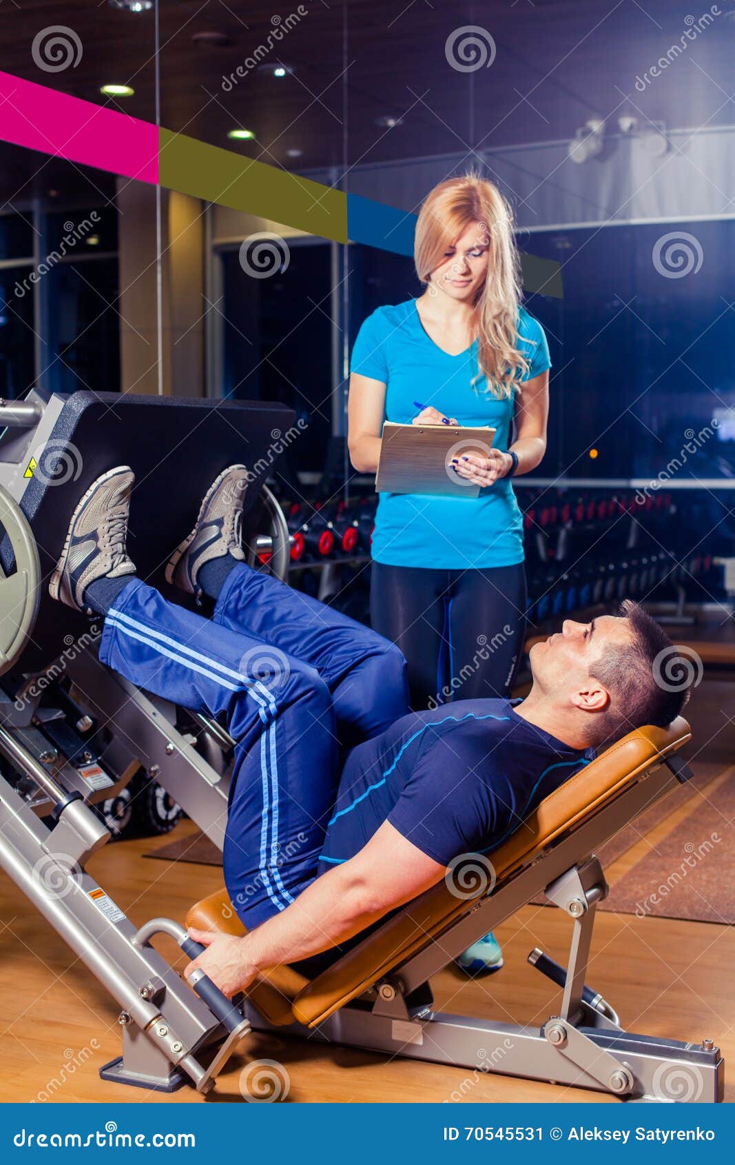 Personal Trainer Helping a Men Working Out on Leg Press Machine in Gym ...