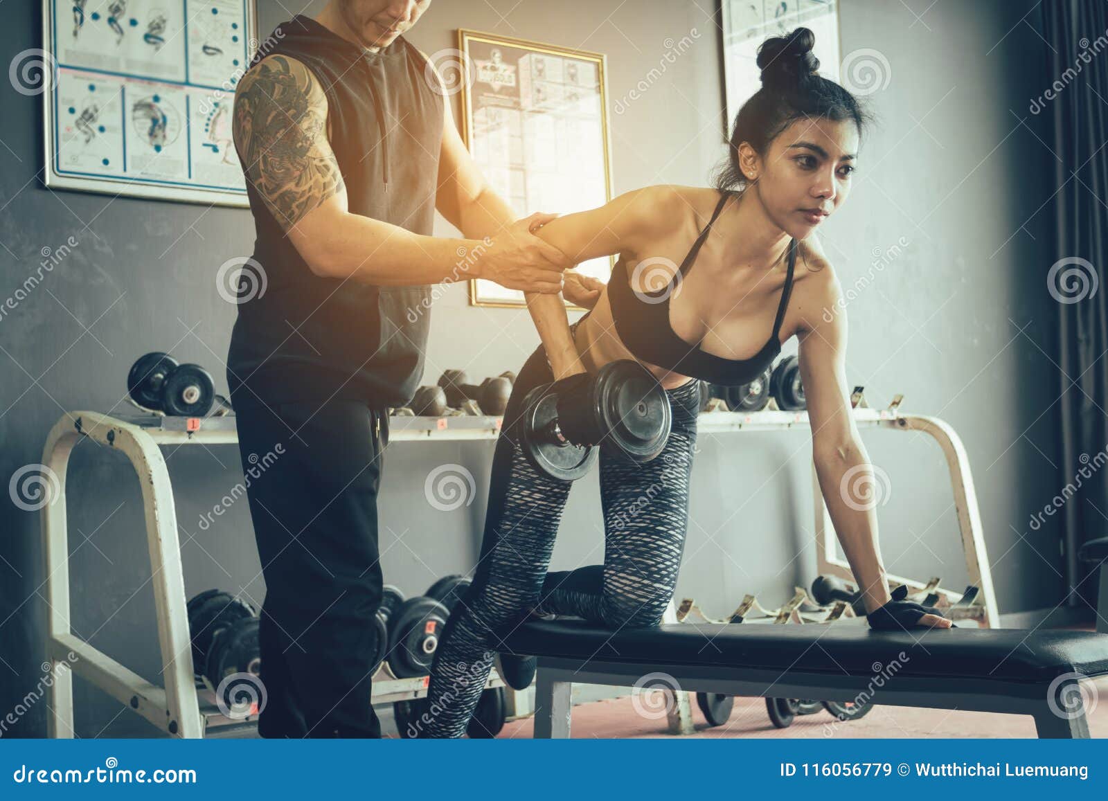 Personal Trainer Helping Woman Working Lift Heavy Dumbbells Stock