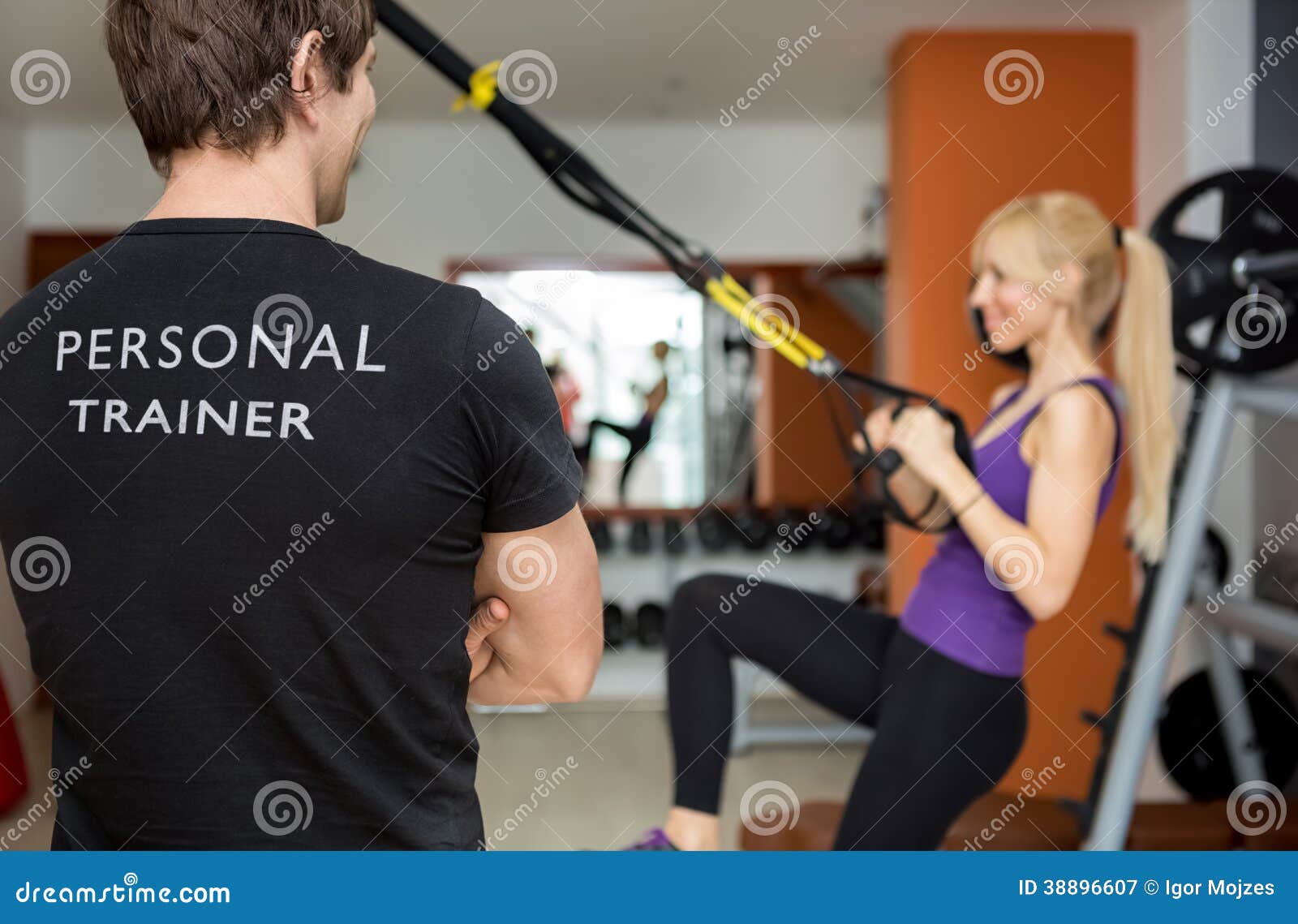 Personal Trainer Coaching Female Bodybuilder Using Weight Machine ...