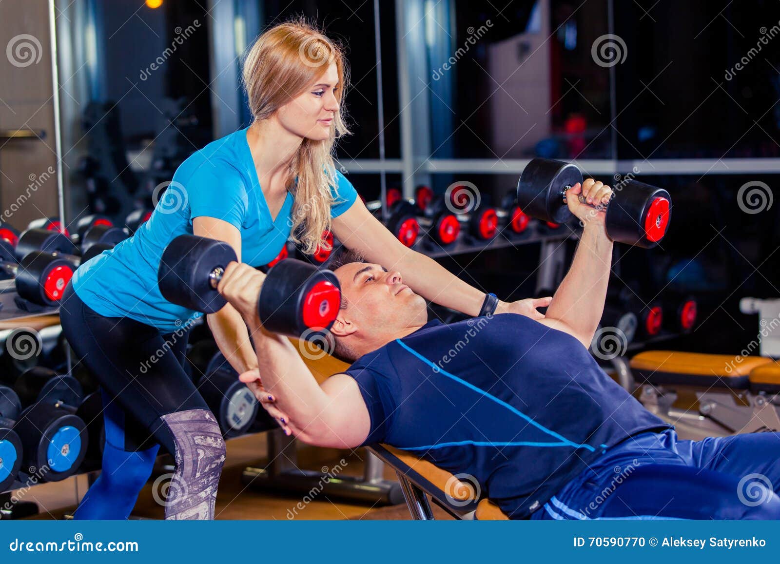 Personal Trainer Woman Helping Men Working With Heavy Dumbbells Stock