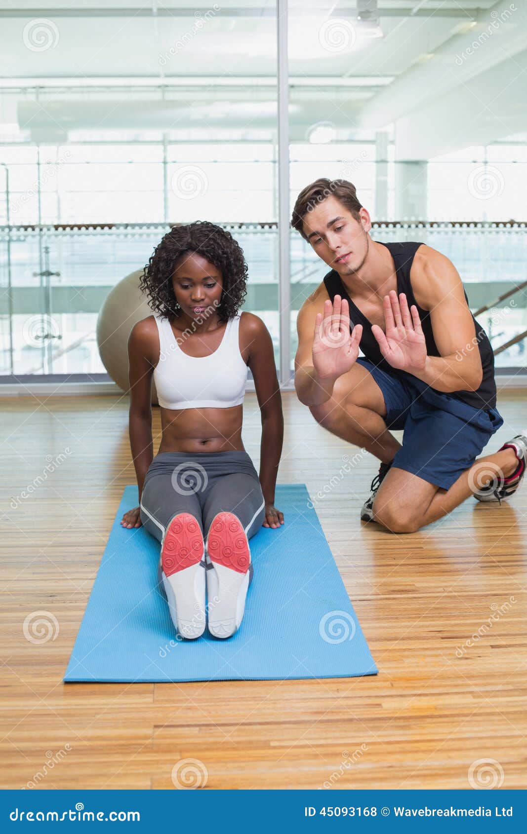 Personal Trainer Working with Client on Exercise Mat Stock Photo ...