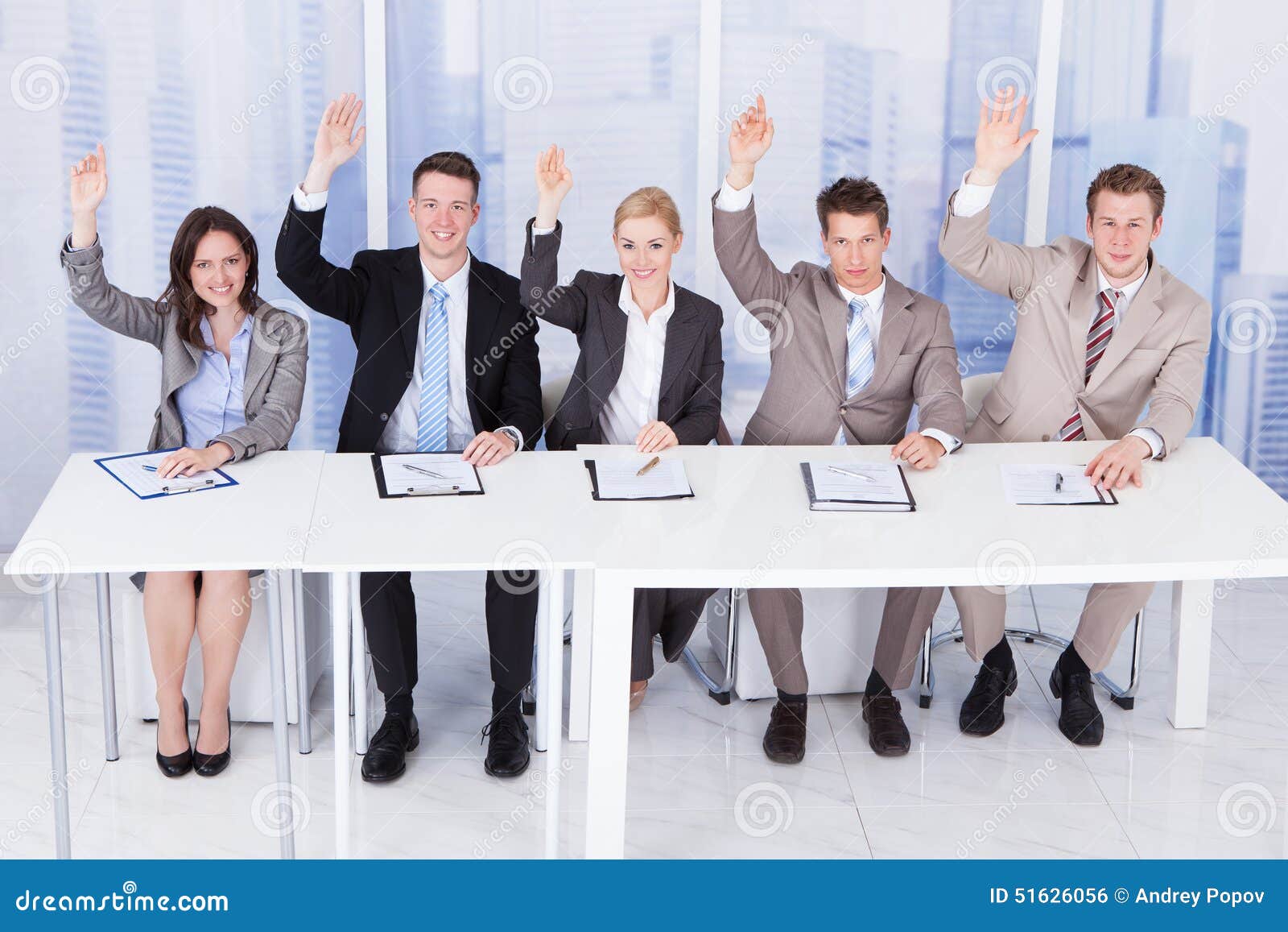 Personnel Officers Sitting with Hands Raised at Table Stock Photo ...