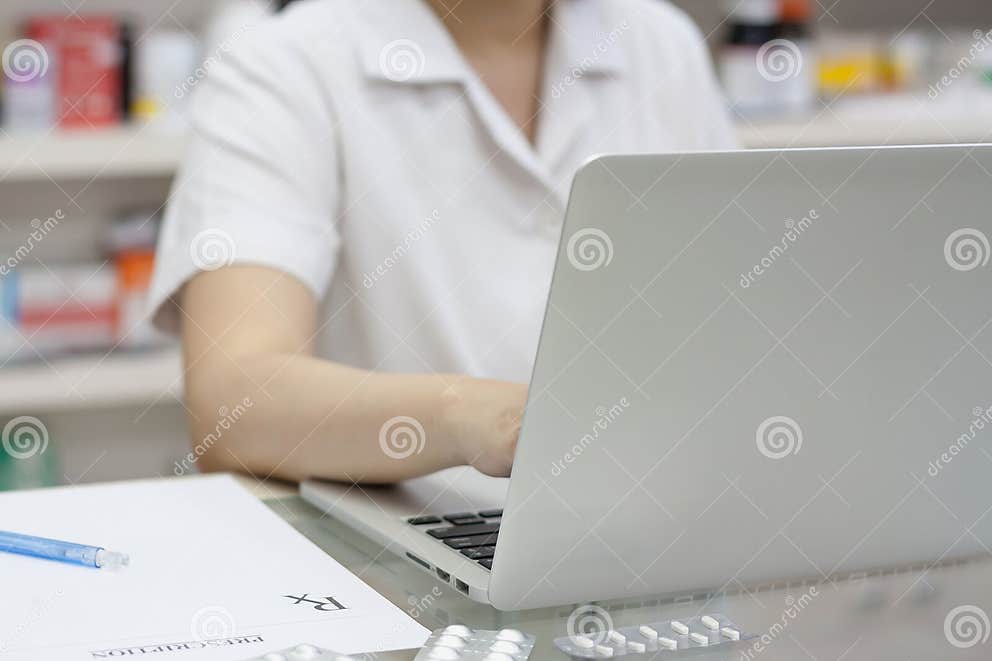 Pharmacist with Laptop Computer and Medication in the Pharmacy Stock ...