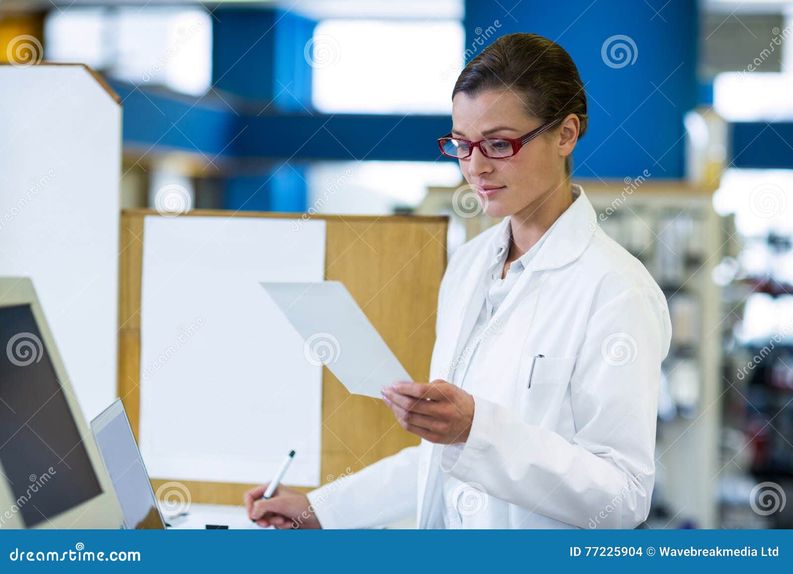 Pharmacist Looking at Prescription and Writing on Book Stock Photo ...