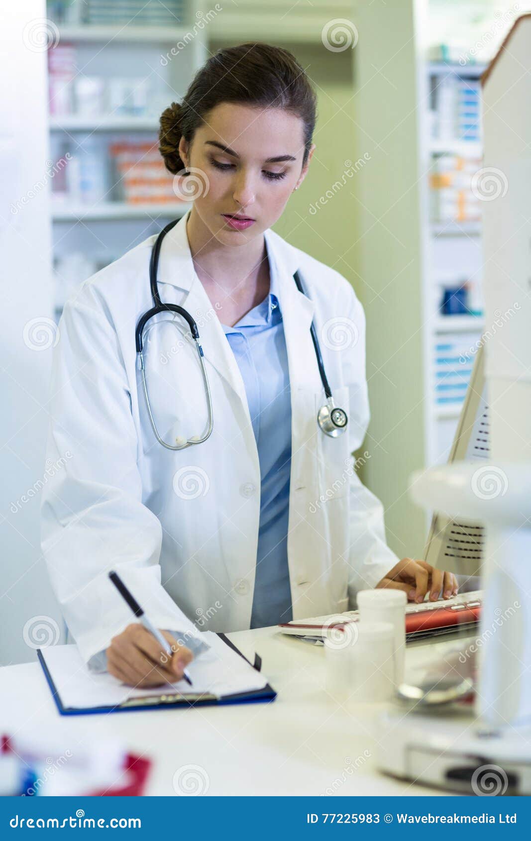 Pharmacist Standing at Counter and Writing on Clipboard Stock Image ...