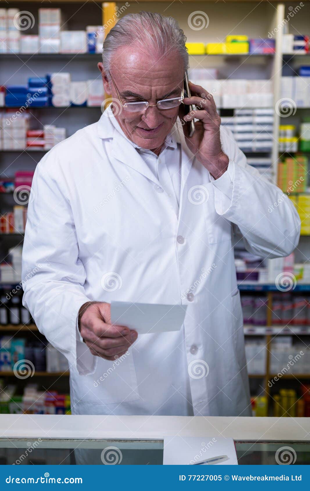 Pharmacist Talking on Mobile Phone while Checking Prescription Stock ...