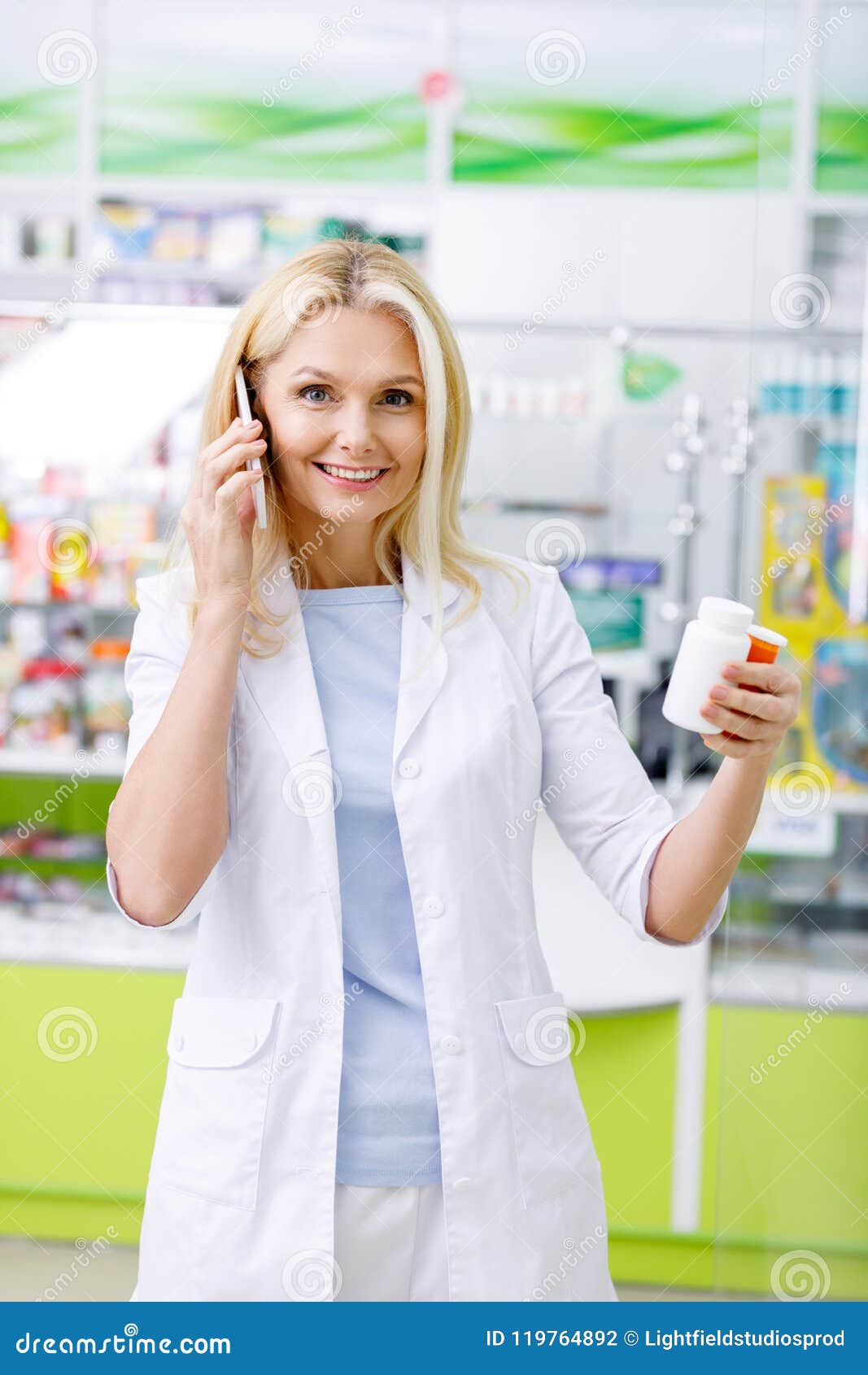 Pharmacist Talking on Smartphone while Holding Containers with Pills ...