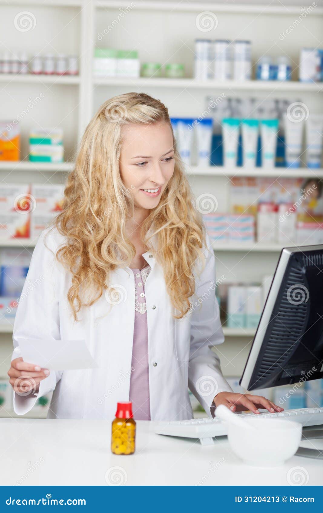 Pharmacist Using Computer while Holding Prescription Paper Stock Image ...