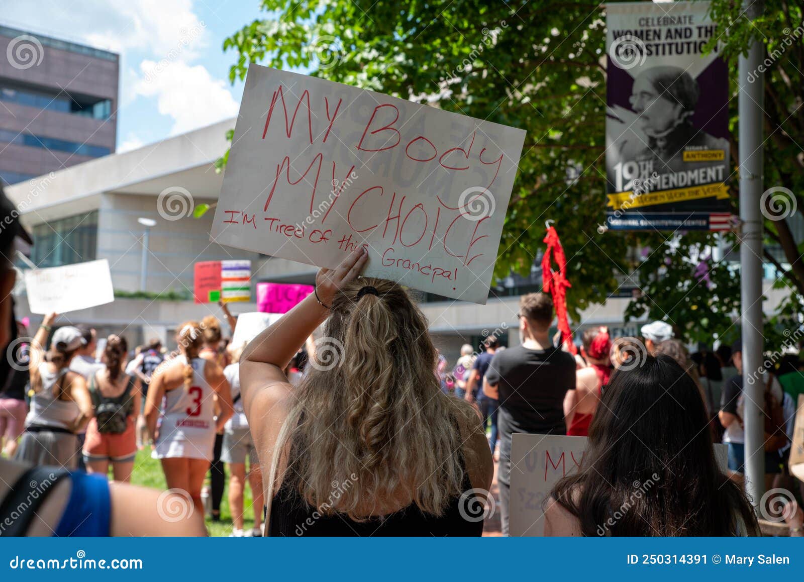 Young Woman In A Crowd Holds A Feminist Protest Sign At Pro Choice