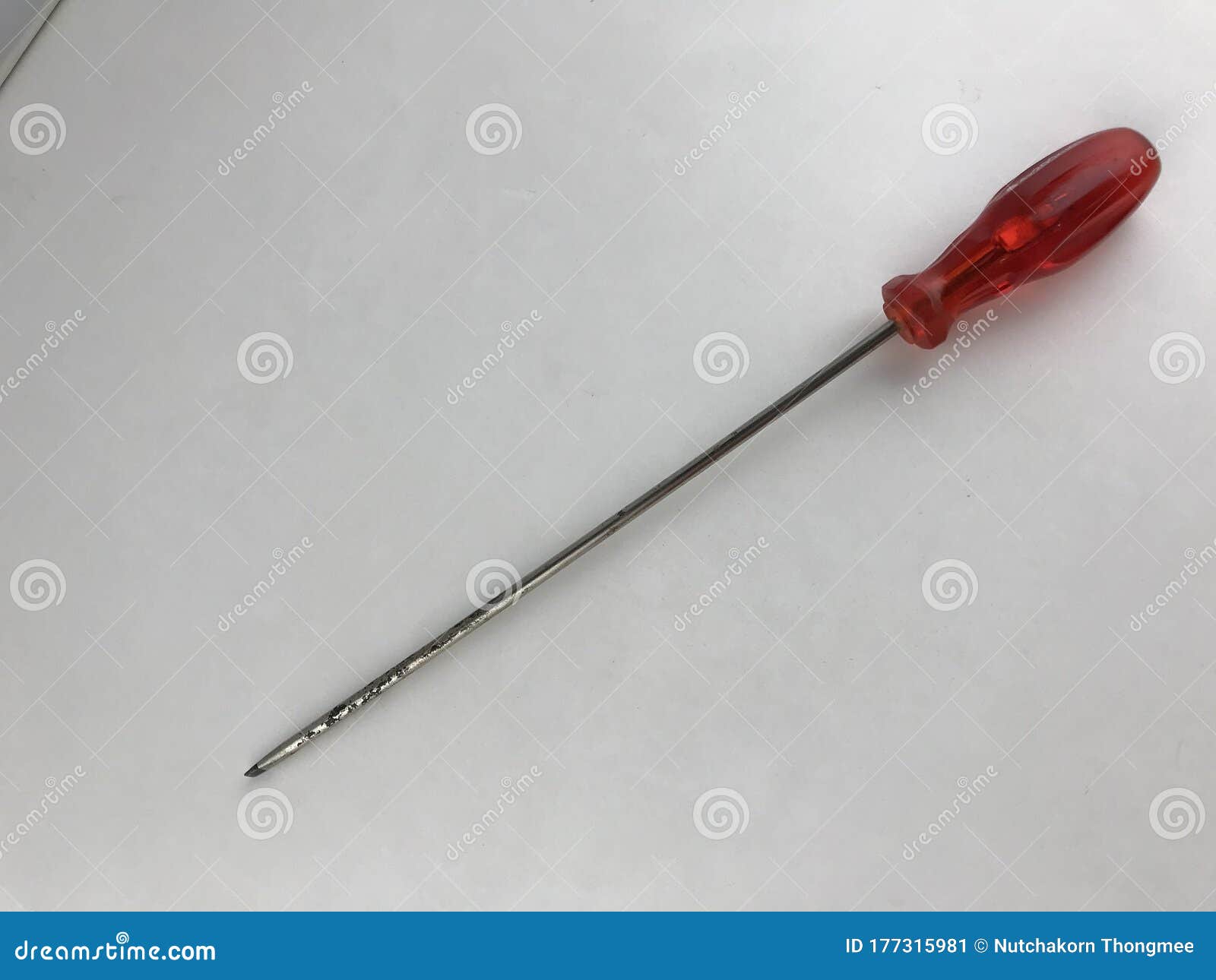 A Phillips-shaped Screwdriver with a Red Plastic Handle Placed on a ...