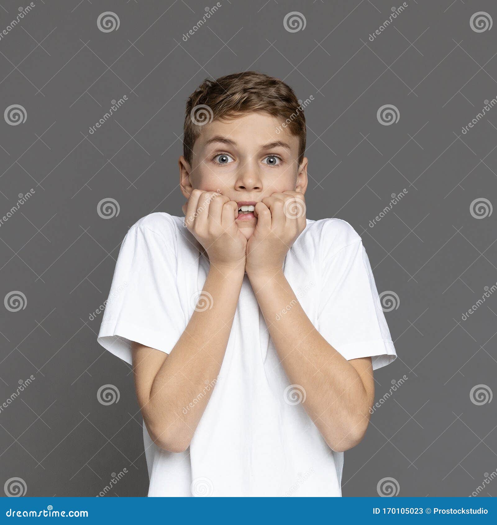 Scared Teenager Biting Fingernails, Grey Studio Background Stock Image ...