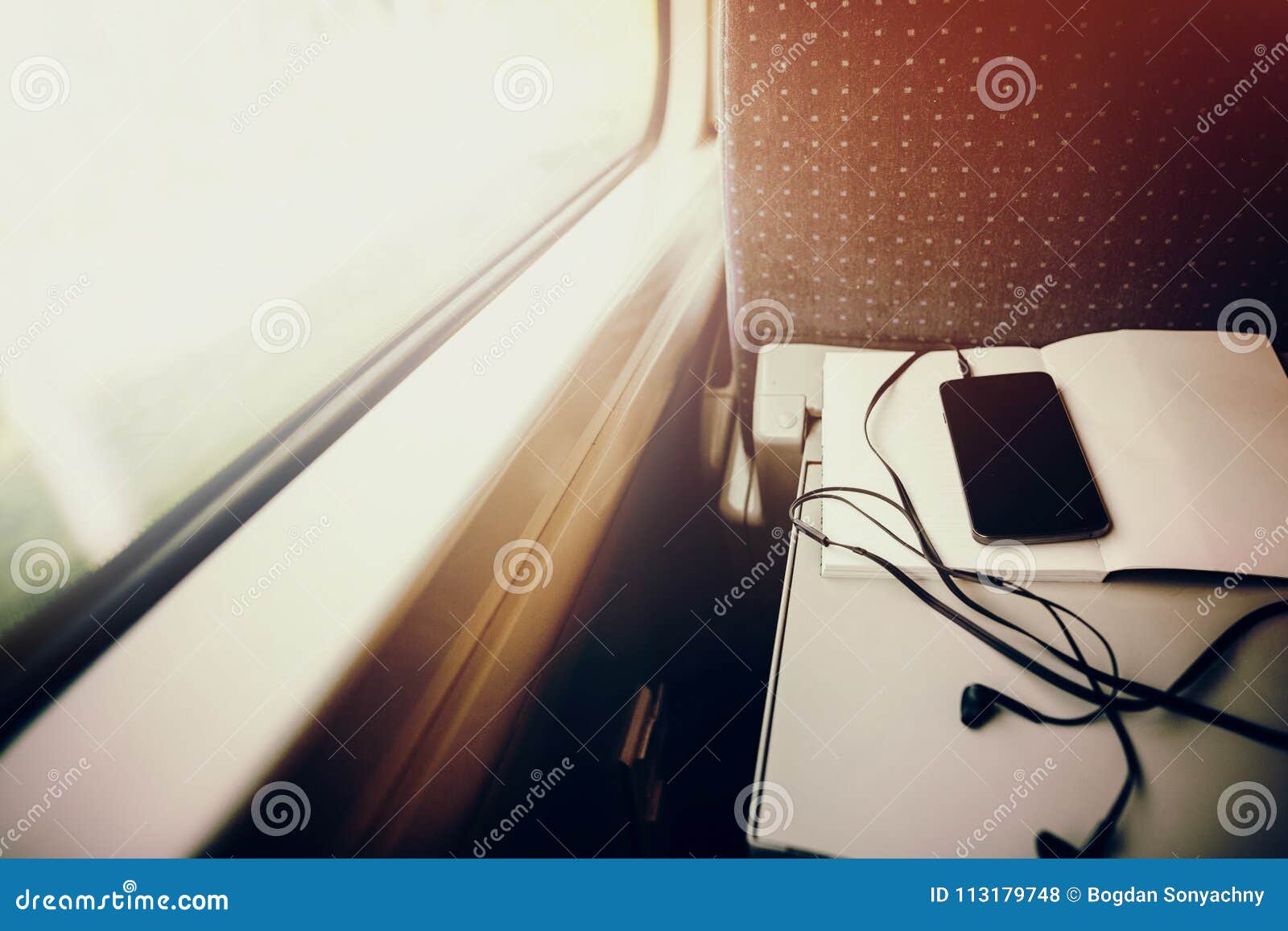 Phone with Headphones on Notebook at Window Light in Train. Smartphone ...