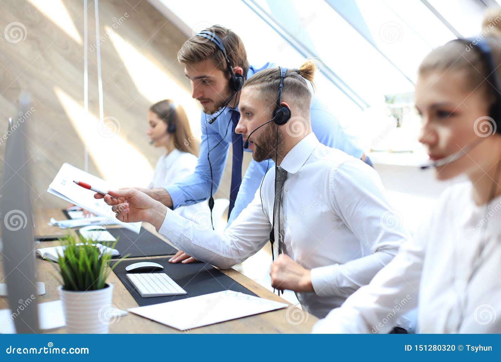Phone Operator Working at Call Centre Office Helping His Colleague ...