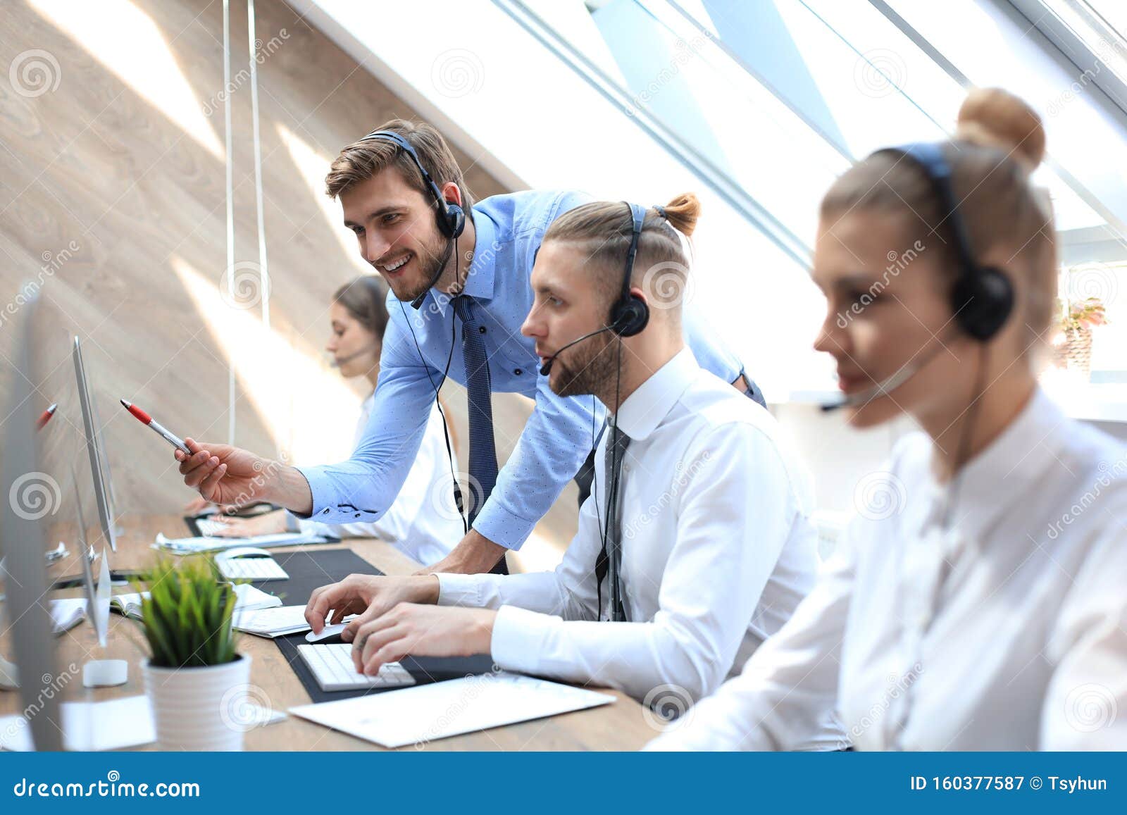 Phone Operator Working at Call Centre Office Helping His Colleague ...