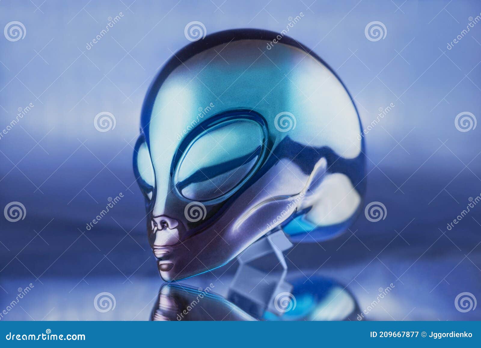 Alien Metal Head Statue on Blue Background on the Table Stock Image ...