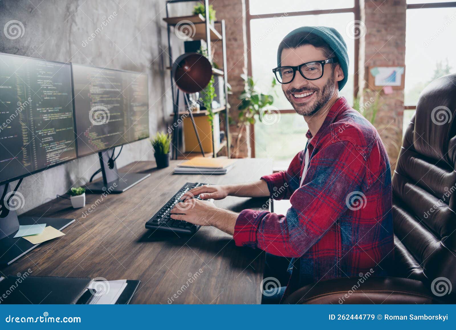 Photo of Cheerful Positive Coder Dressed Hat Glasses Smiling Writing ...