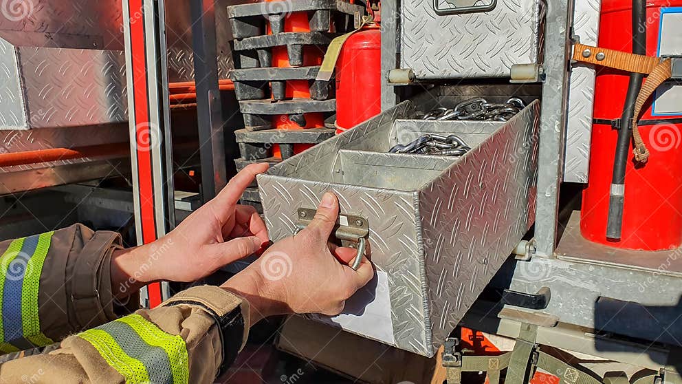 Photo of Firefighter Pulling Chains on Fire Truck Stock Image - Image ...