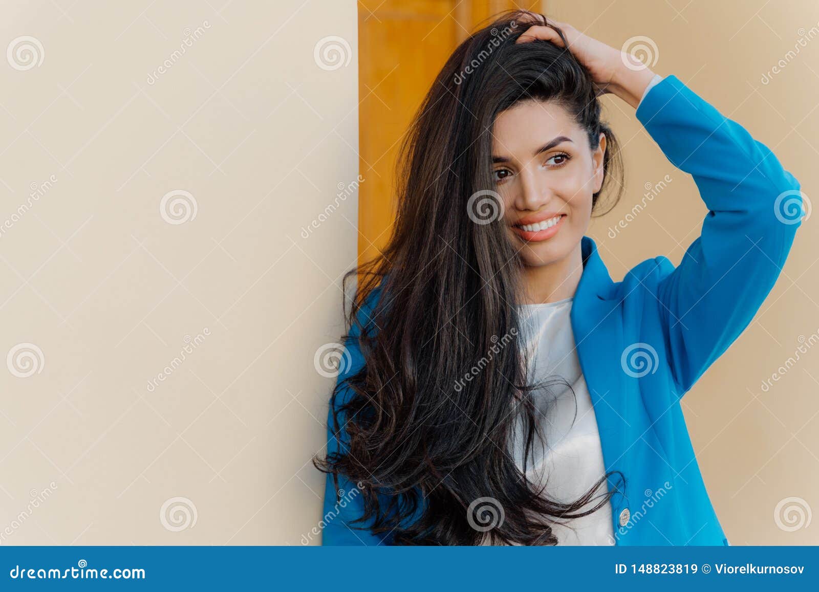 Photo Of Good Looking Gorgeous Brunette Woman Keeps Hand On Head Has