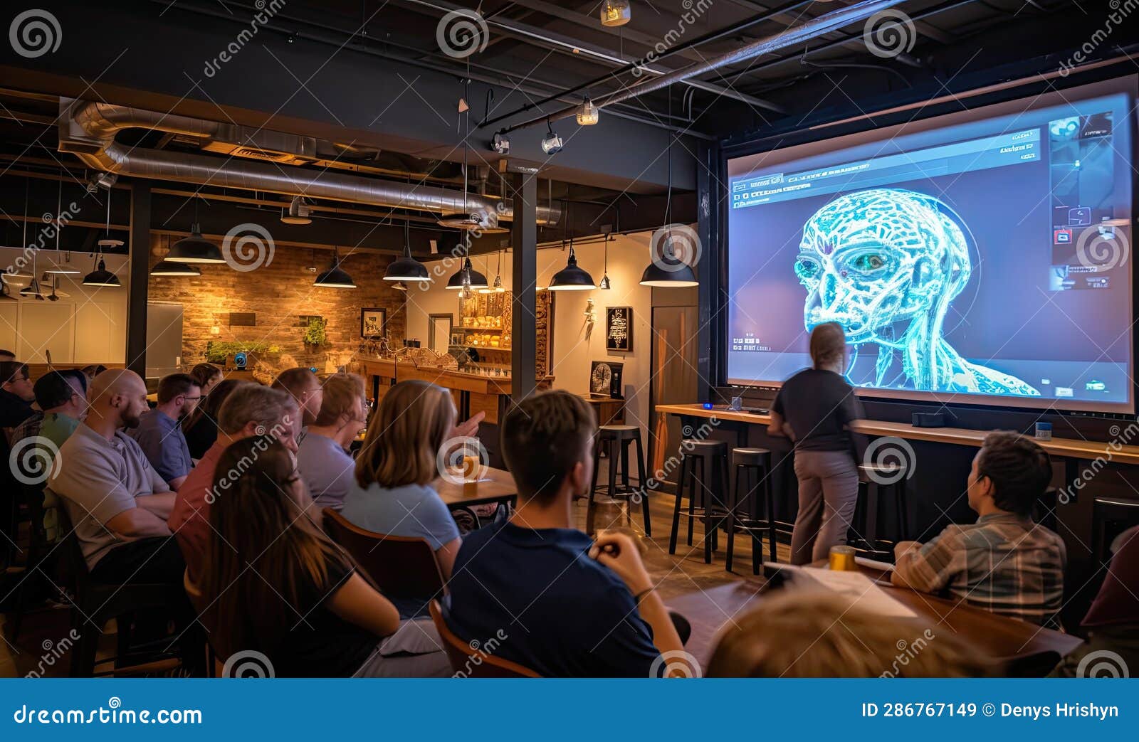 Photo of a Group of People Sitting in Front of a Projection Screen ...