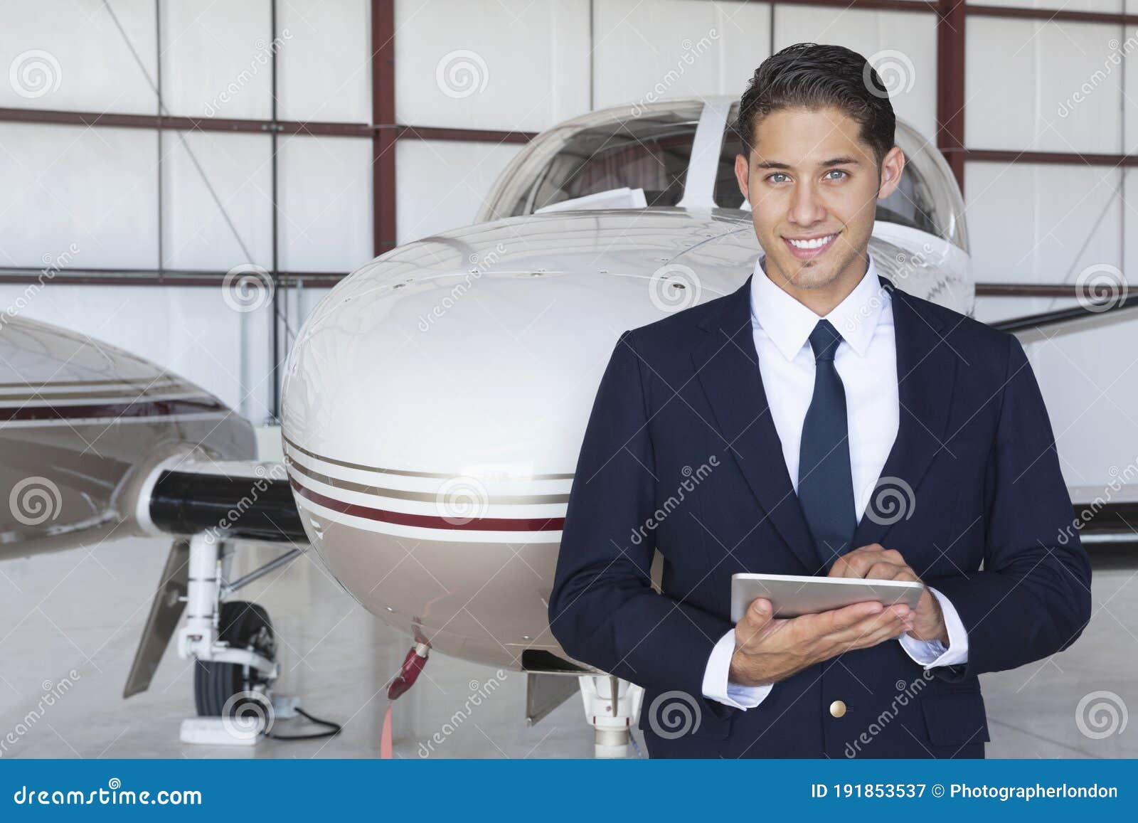 Portrait of Handsome Young Pilot Using Tablet PC in Front of Airplane ...