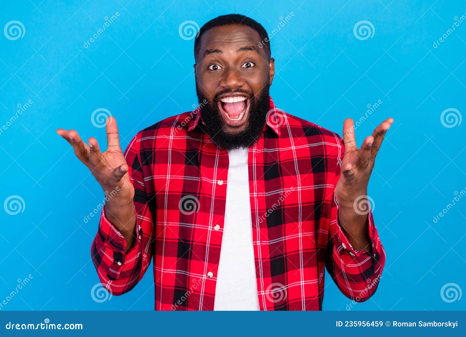 Photo Of Impressed Young Brunet Guy Hands Up Wear Red Shirt Isolated On