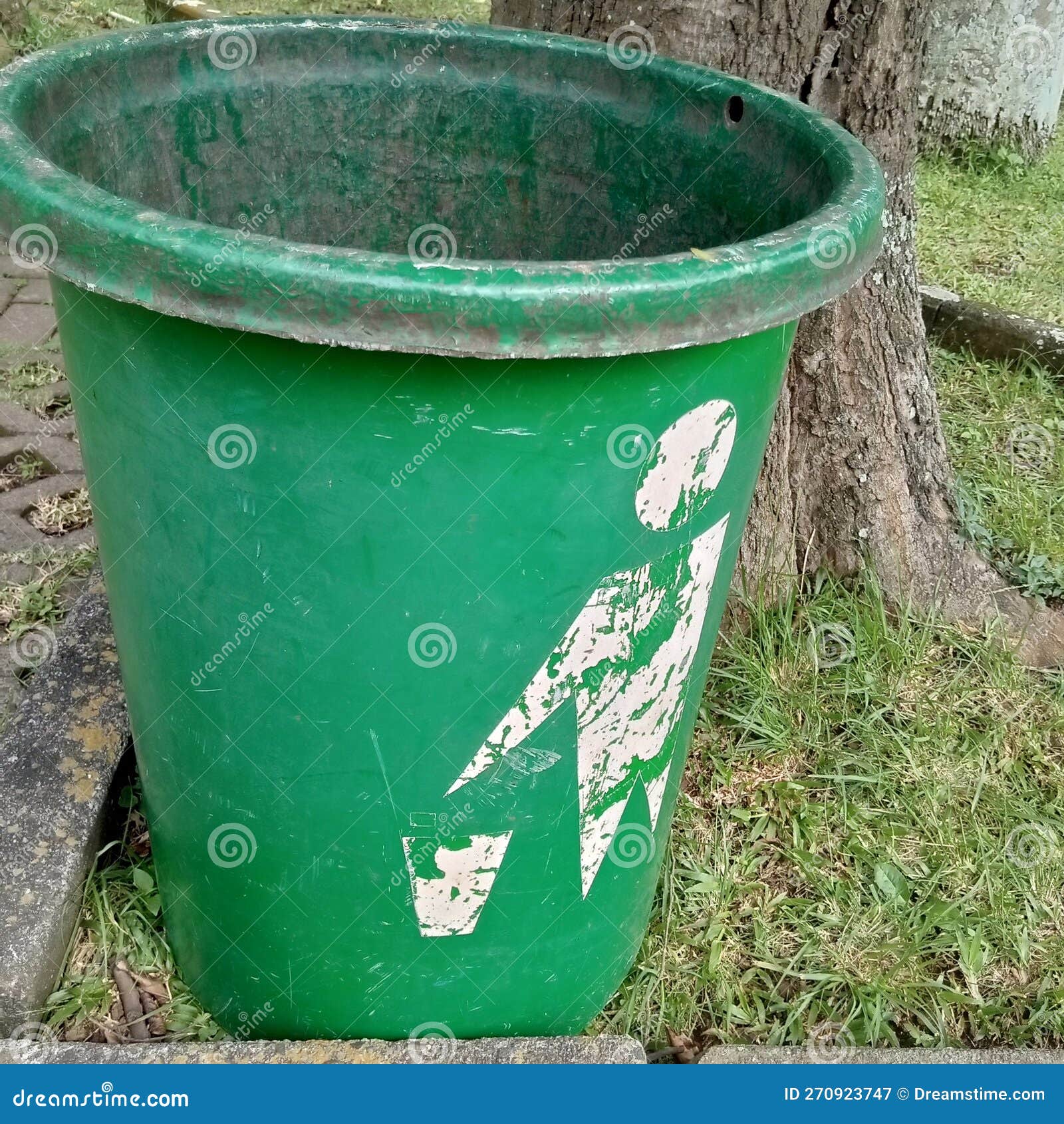 Photo of a Large Green Trash Can Under a Tree with a Slightly Dull ...