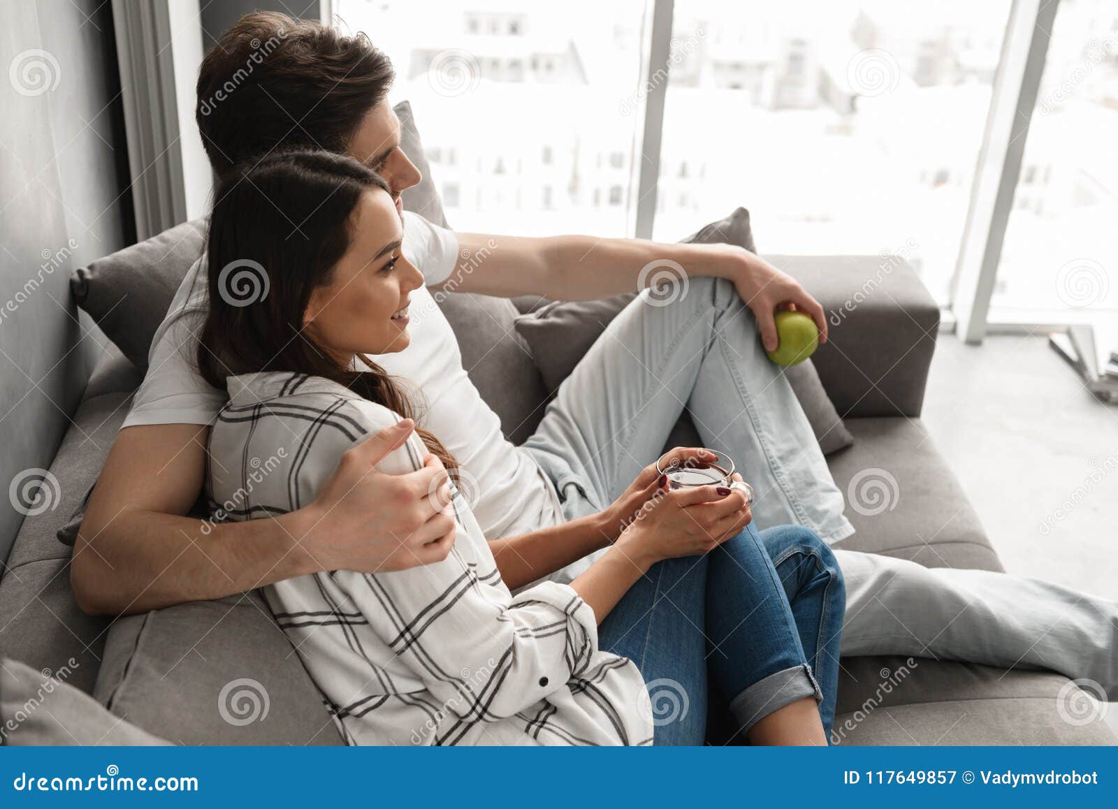 Photo Of Lovely Couple Man And Woman Sitting On Sofa In Apartment Near