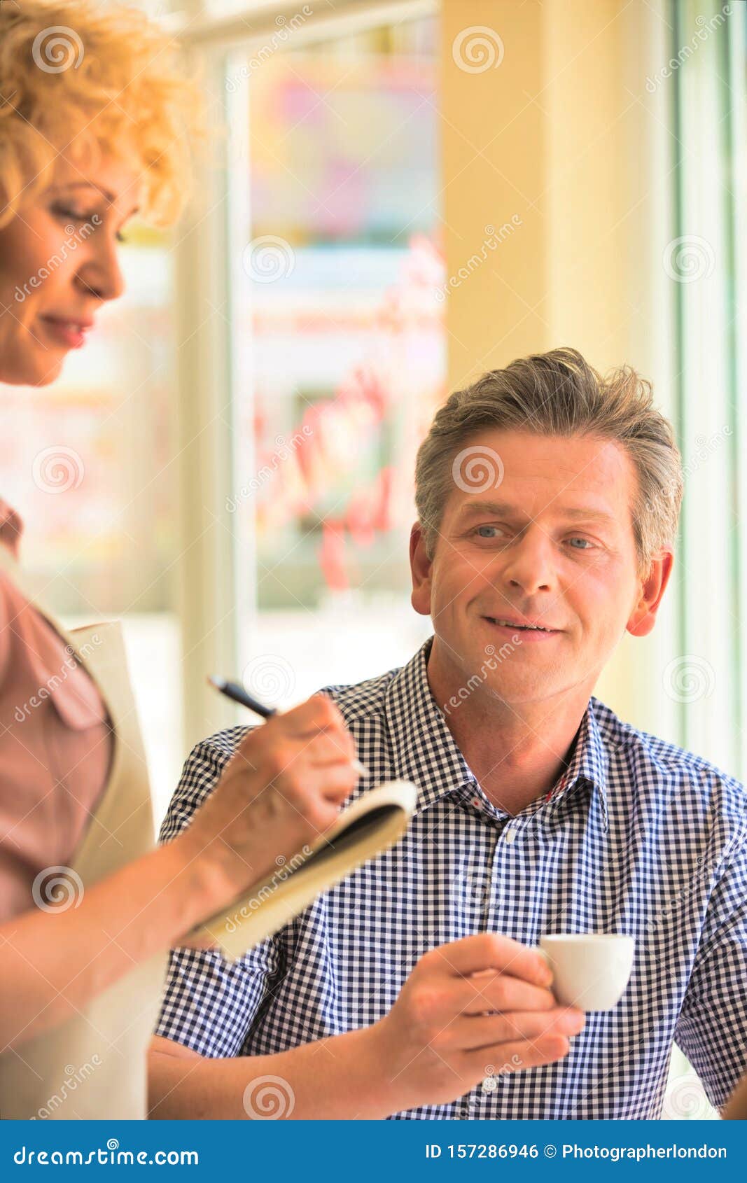 Man Looking at Waitress Writing Order on Notepad at Restaurant Stock ...