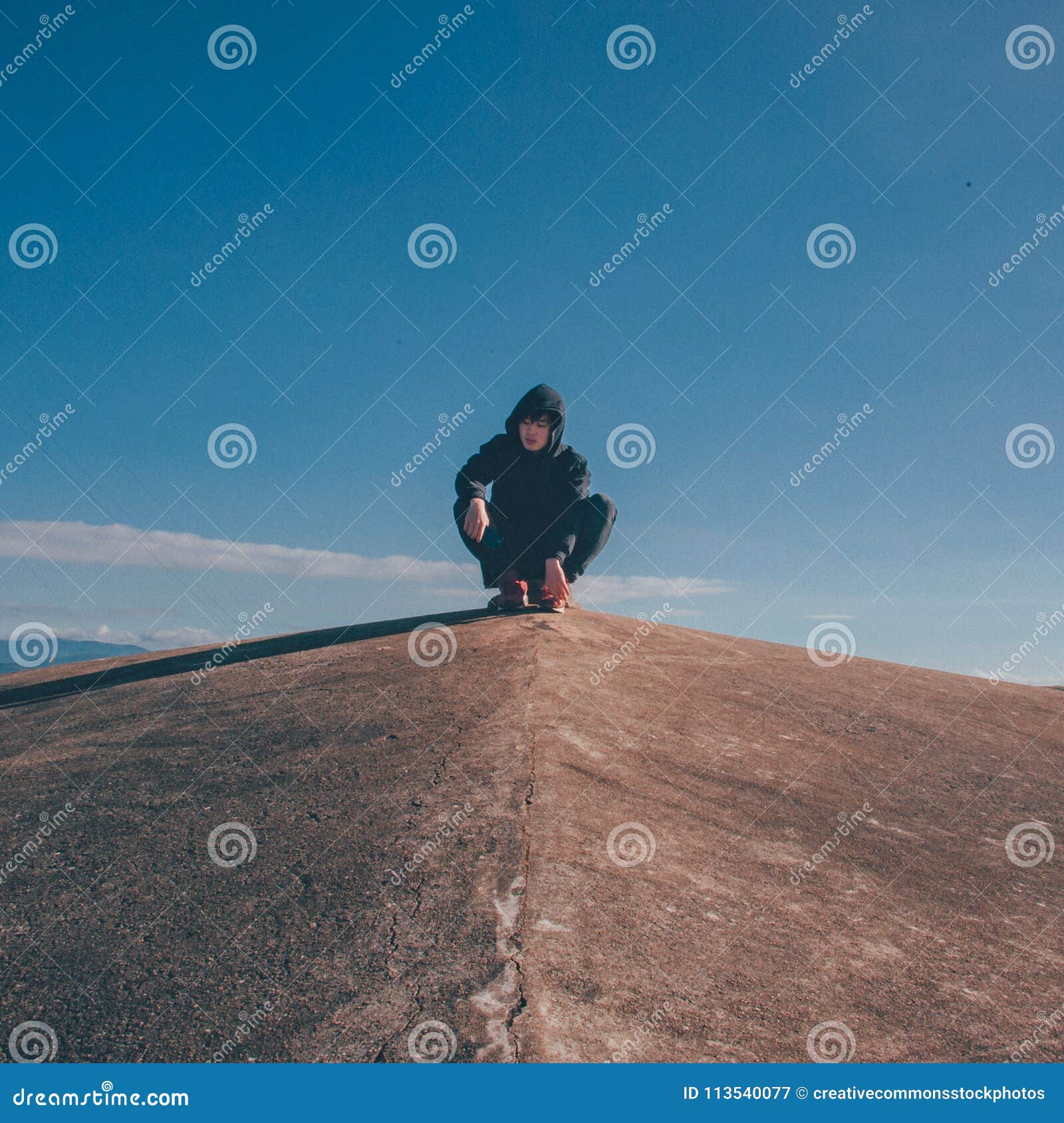 Photo Of Man In The Middle Of Concrete Cliff Picture. Image: 113540077