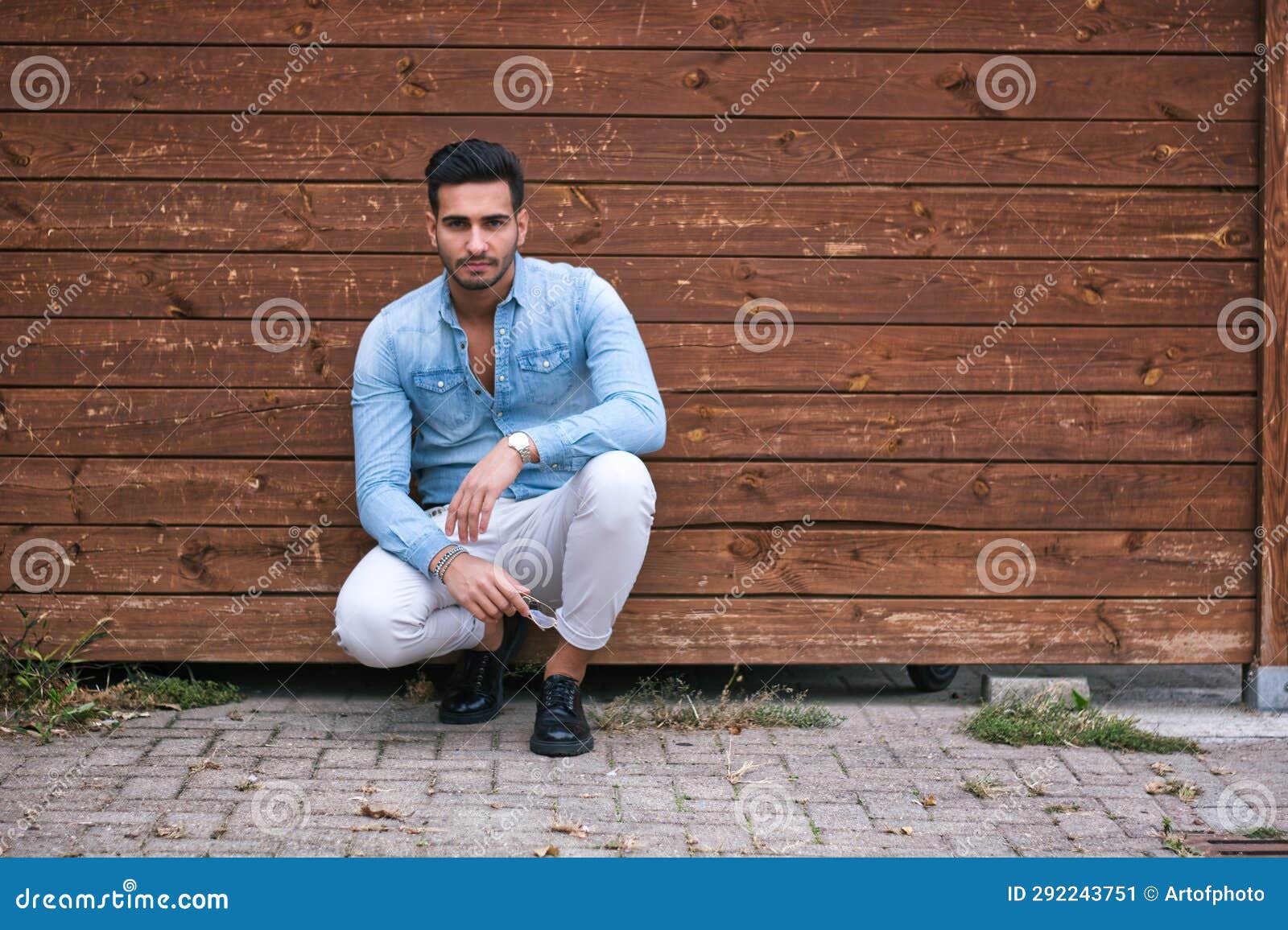 Photo of a Man Sitting in Front of a Rustic Wooden Wall Stock Image ...