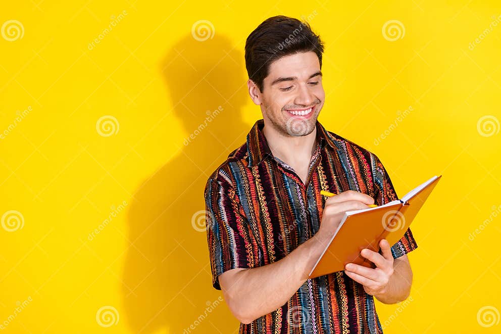 Photo of Nice Young Man Write Notebook Wear Shirt Isolated on Yellow ... Photo of Nice Young Man Write Notebook Wear Shirt Isolated on Yellow ...