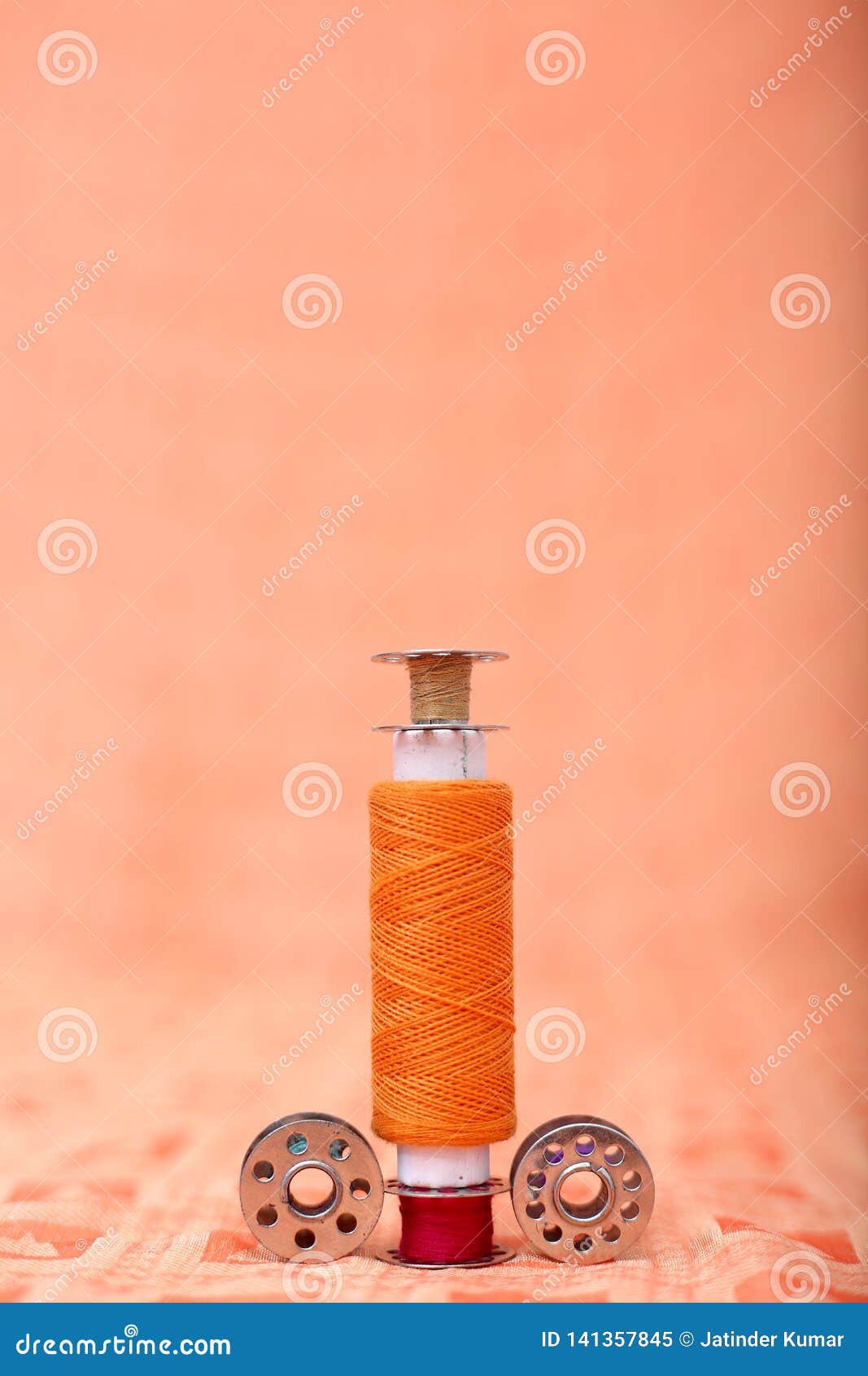 Photo of One Sewing Thread and Bobbin on the Orange Cloth Stock Image ...