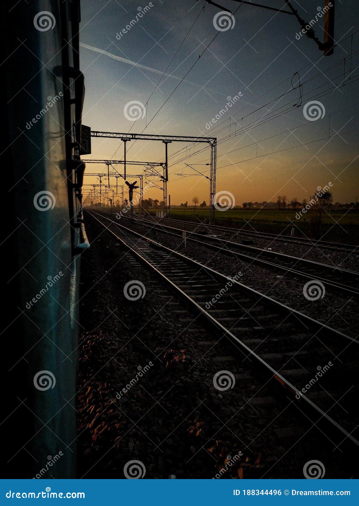The Photo of an Outside View of a Train Moving Towards Sunset ...