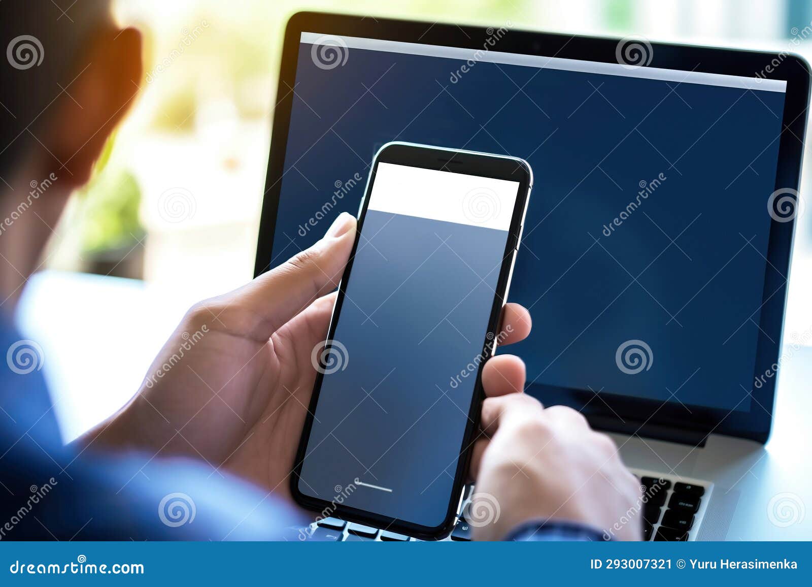 Photo of a Person Using a Cell Phone while Working on a Laptop Stock ...