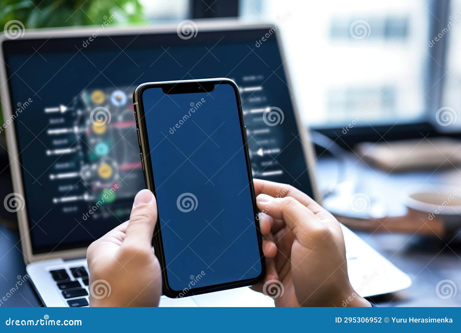 Photo of a Person Using a Cell Phone while Working on a Laptop Stock ...