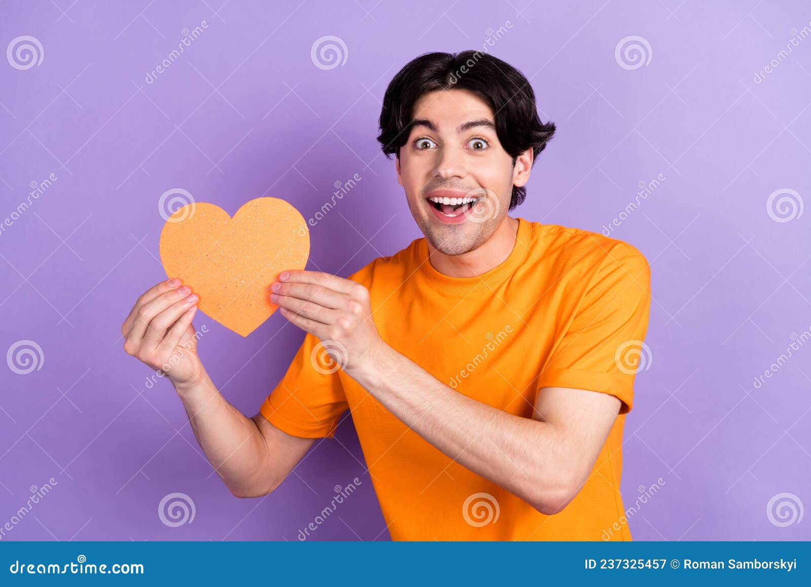 Photo Of Positive Cheerful Happy Young Amazed Man Hold Hands Heart
