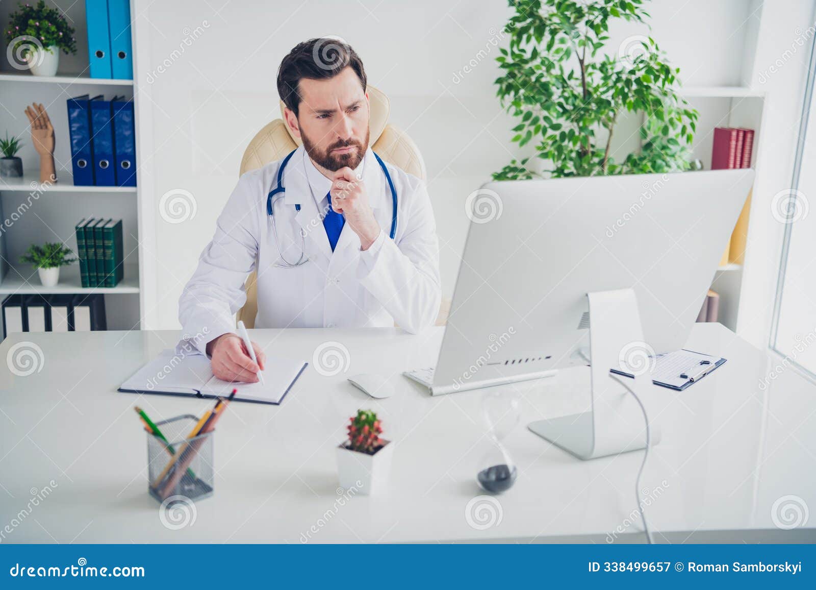 Photo of Serious General Practitioner Guy Sit Desk Write Copybook Look ...