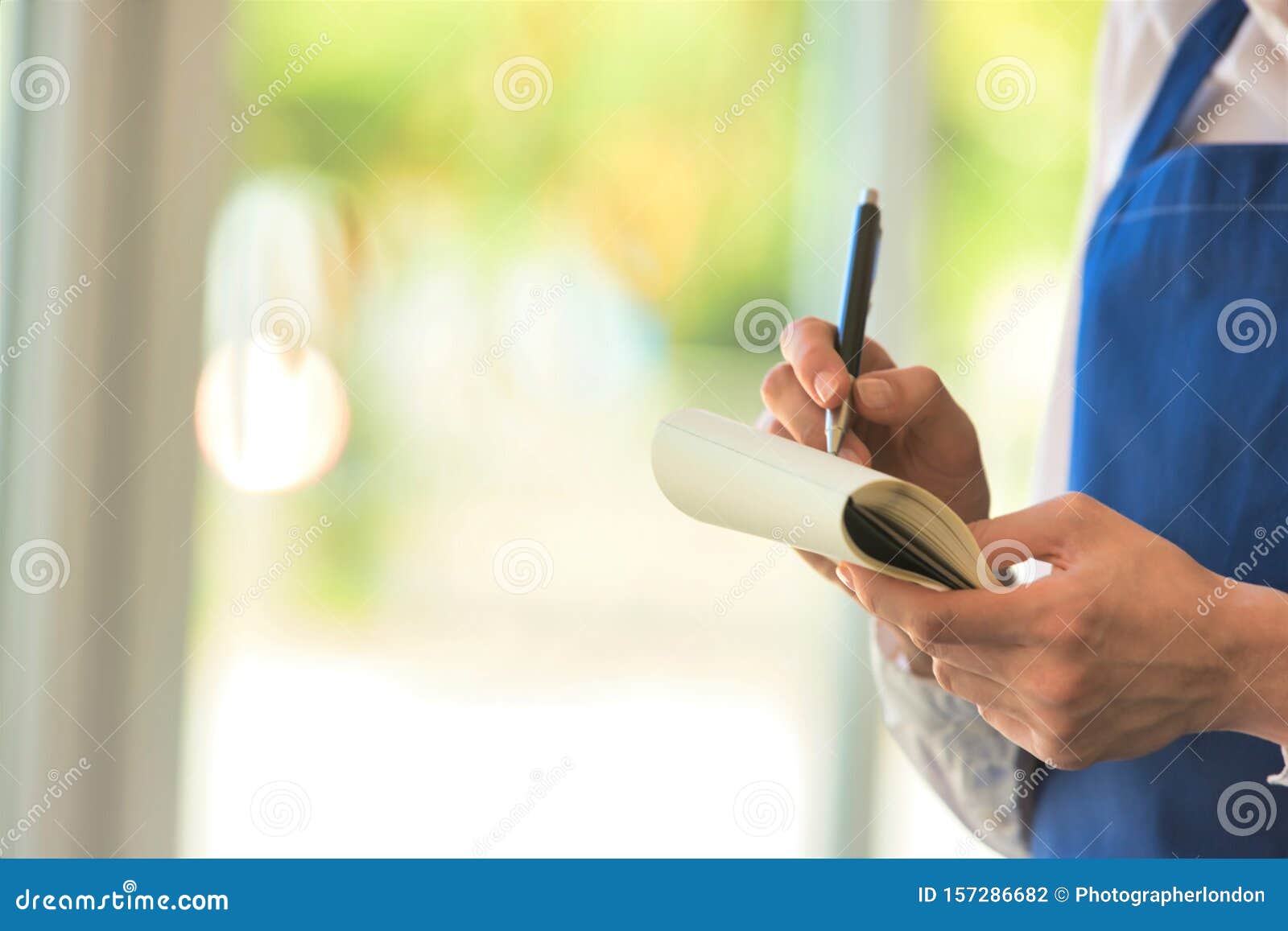 Young Confident Waitress Writing on Notepad at Restaurant Stock Photo ...