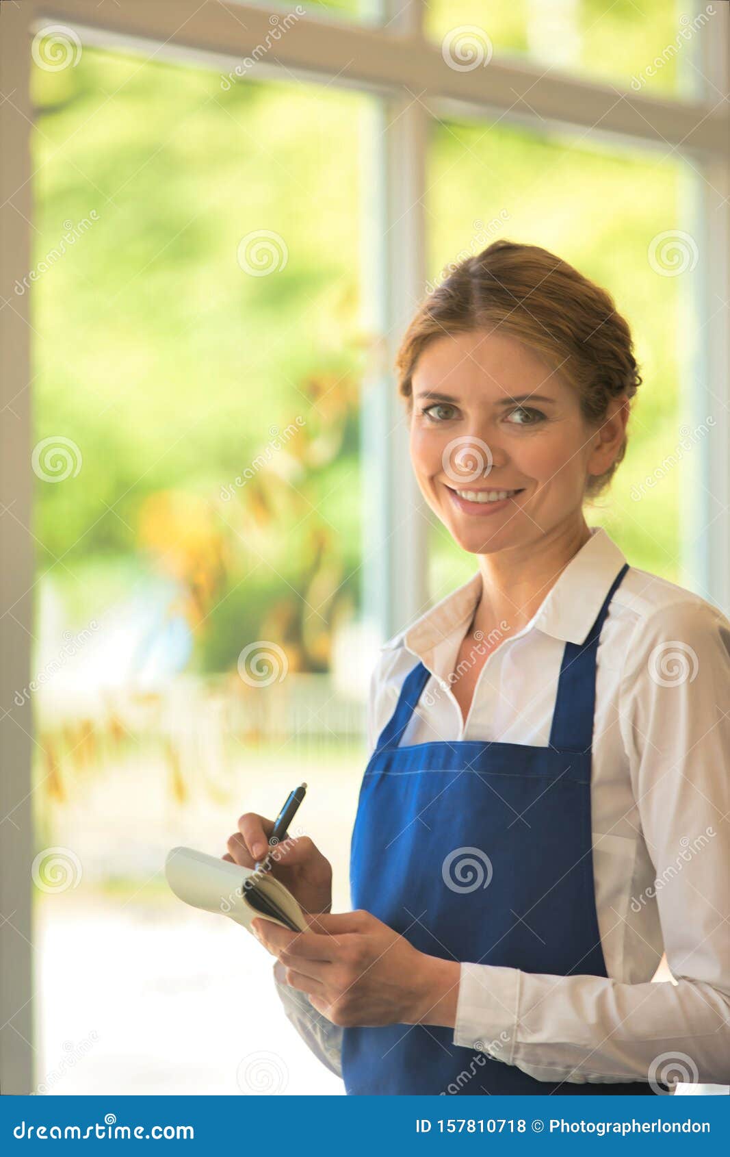 Young Confident Waitress Writing on Notepad at Restaurant Stock Photo ...