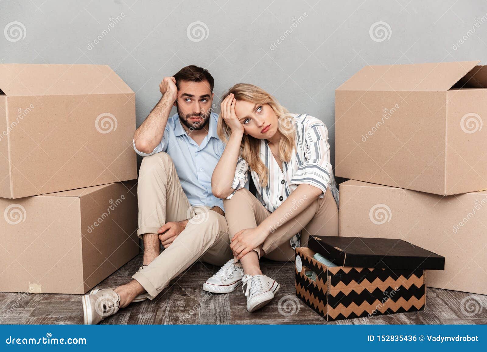 Photo Of Young Couple In Casual Clothing Seating Near Cardboard Boxes