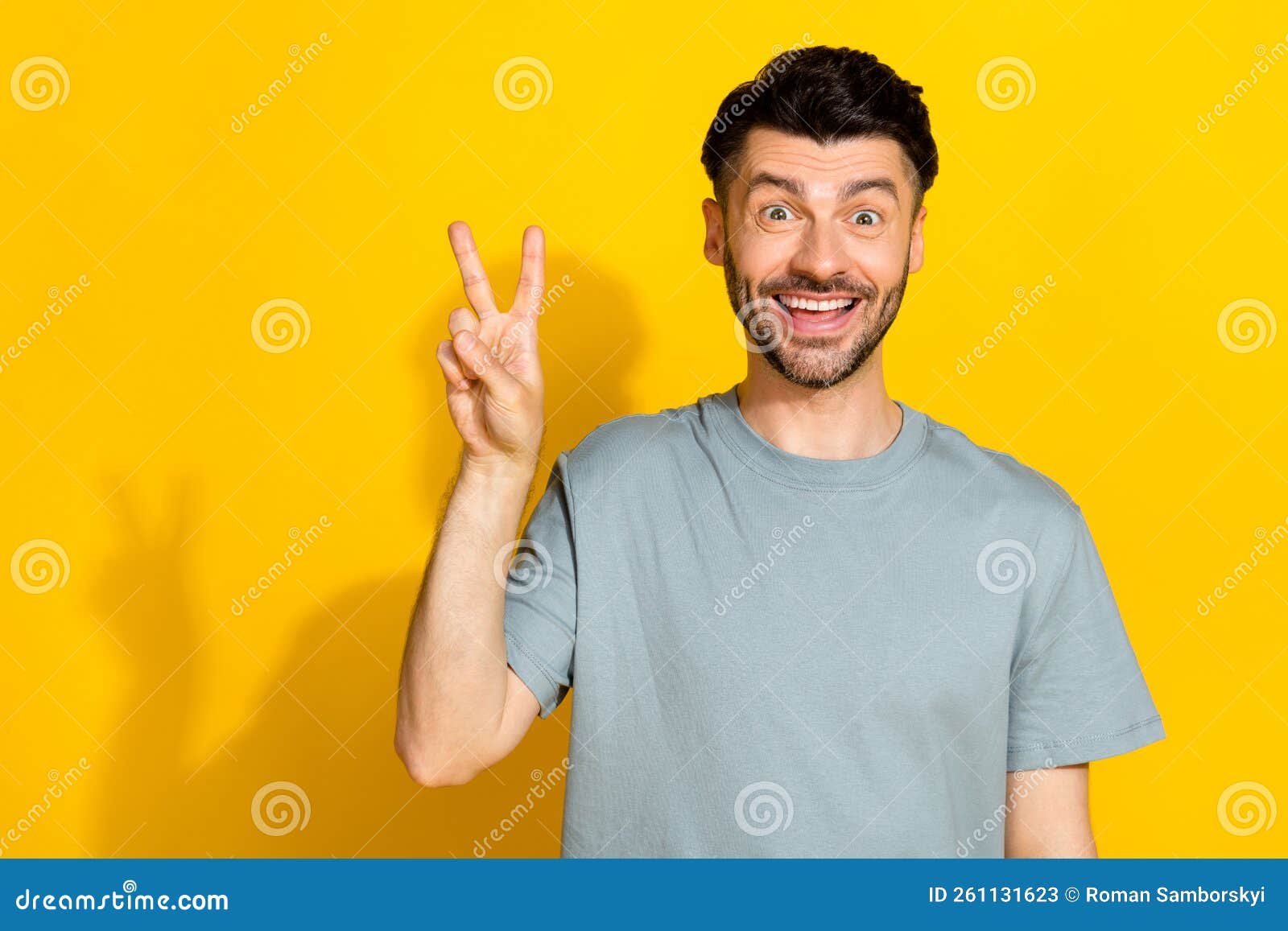 Photo Of Young Funny Positive Bristle Brunet Man Excited Showing V Sign