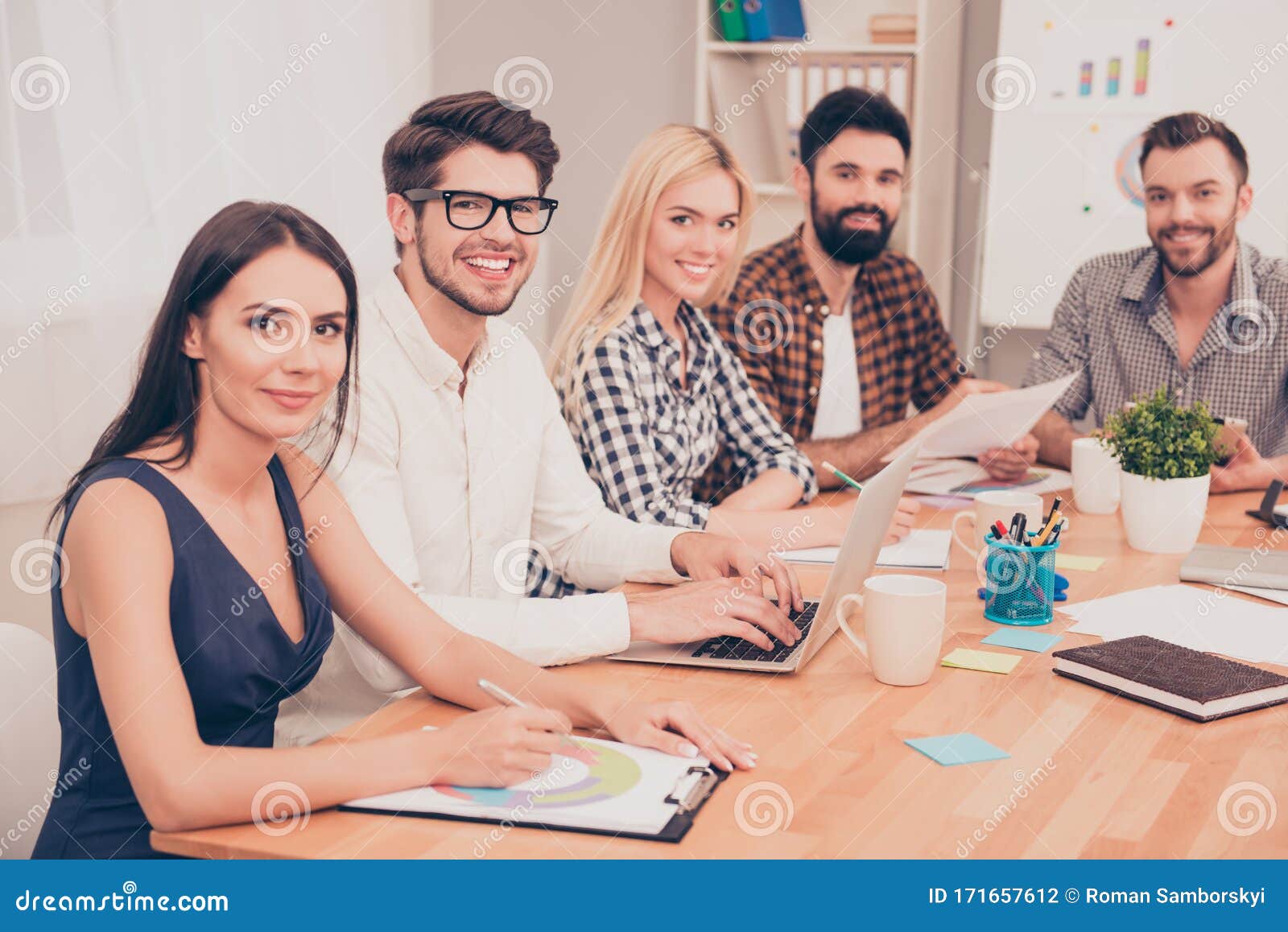 Photo of Young Team Sitting at Conference Table and Smiling Stock Photo ...