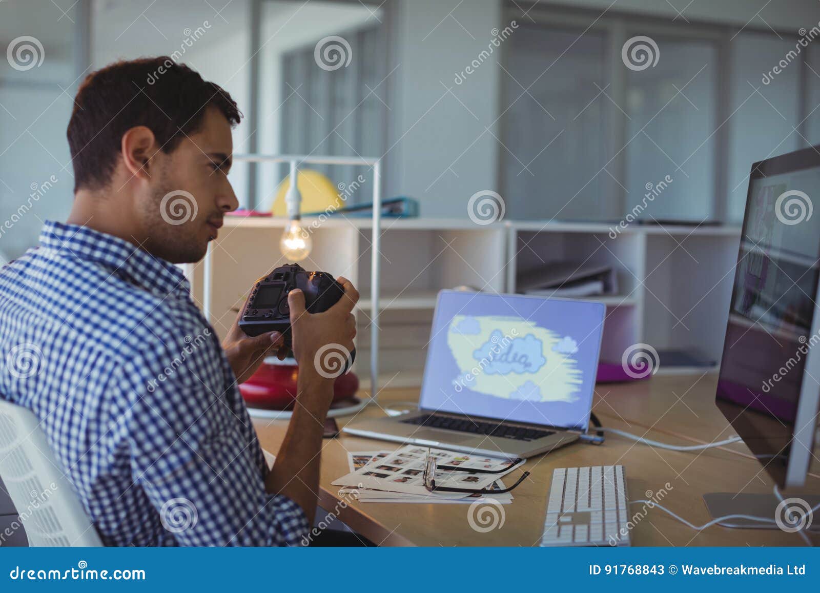 Photographer Holding Camera while Sitting in Creative Office Stock ...