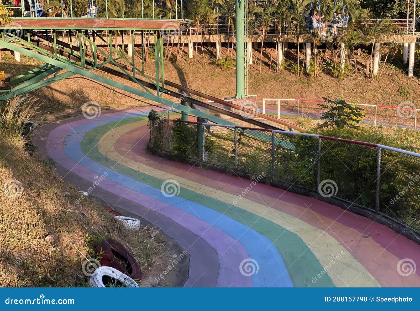 A Photography of a Rainbow Painted Walkway in a Park with a Roller ...