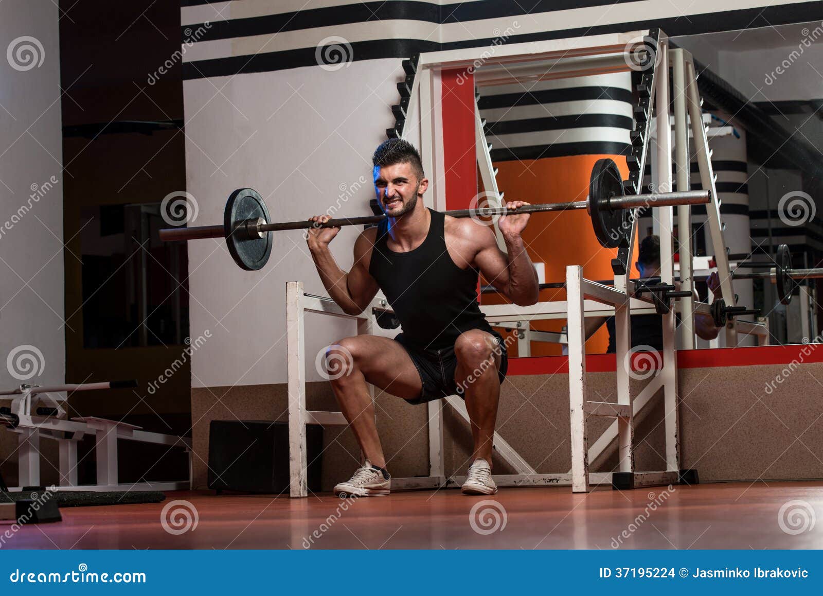 A Physically Fit Men Exercising by Doing Squats Stock Photo - Image of ...