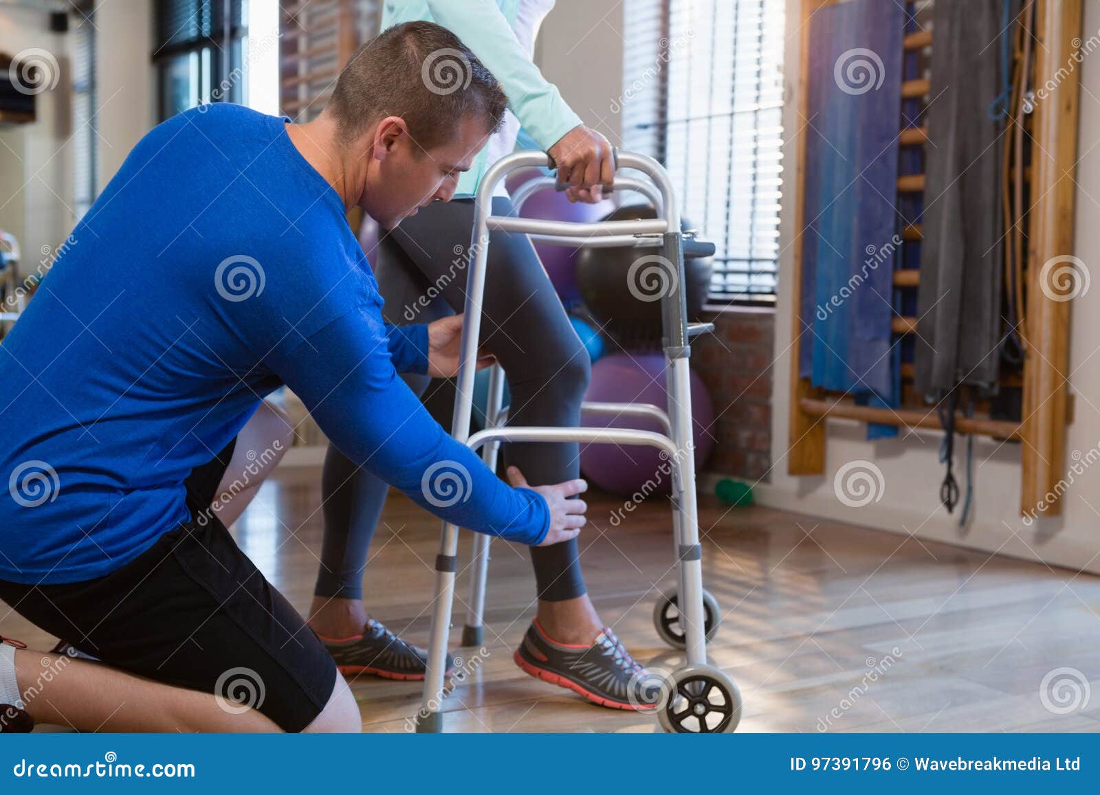 Physiotherapist Helping Patient To Walk with Walking Frame Stock Photo ...